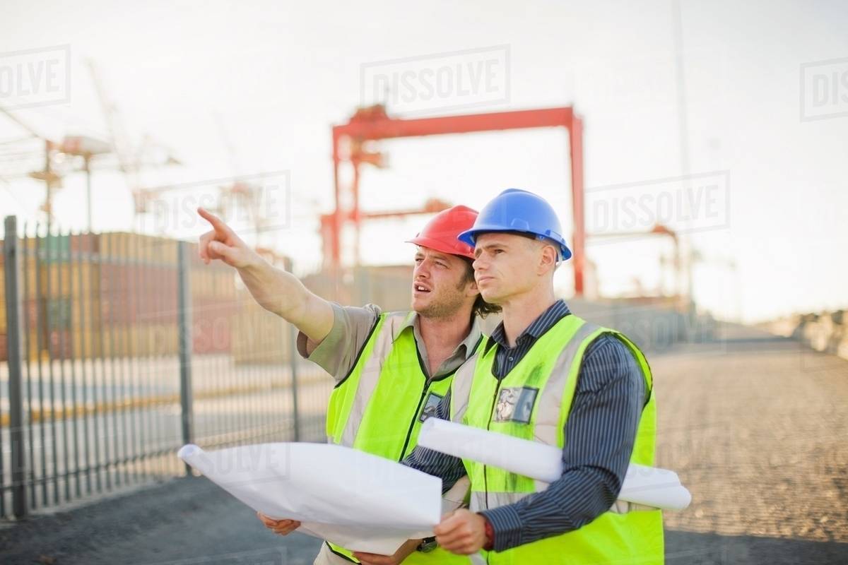 Construction workers talking on site - Royalty-free Stock Photo | Dissolve