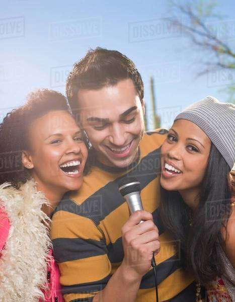 Friends singing together outdoors - Stock Photo - Dissolve