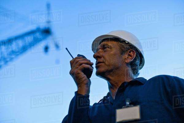Worker using walkie talkie on site - Royalty-free Stock Photo | Dissolve