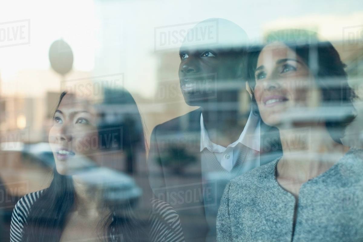 Business people looking out window - Stock Photo - Dissolve