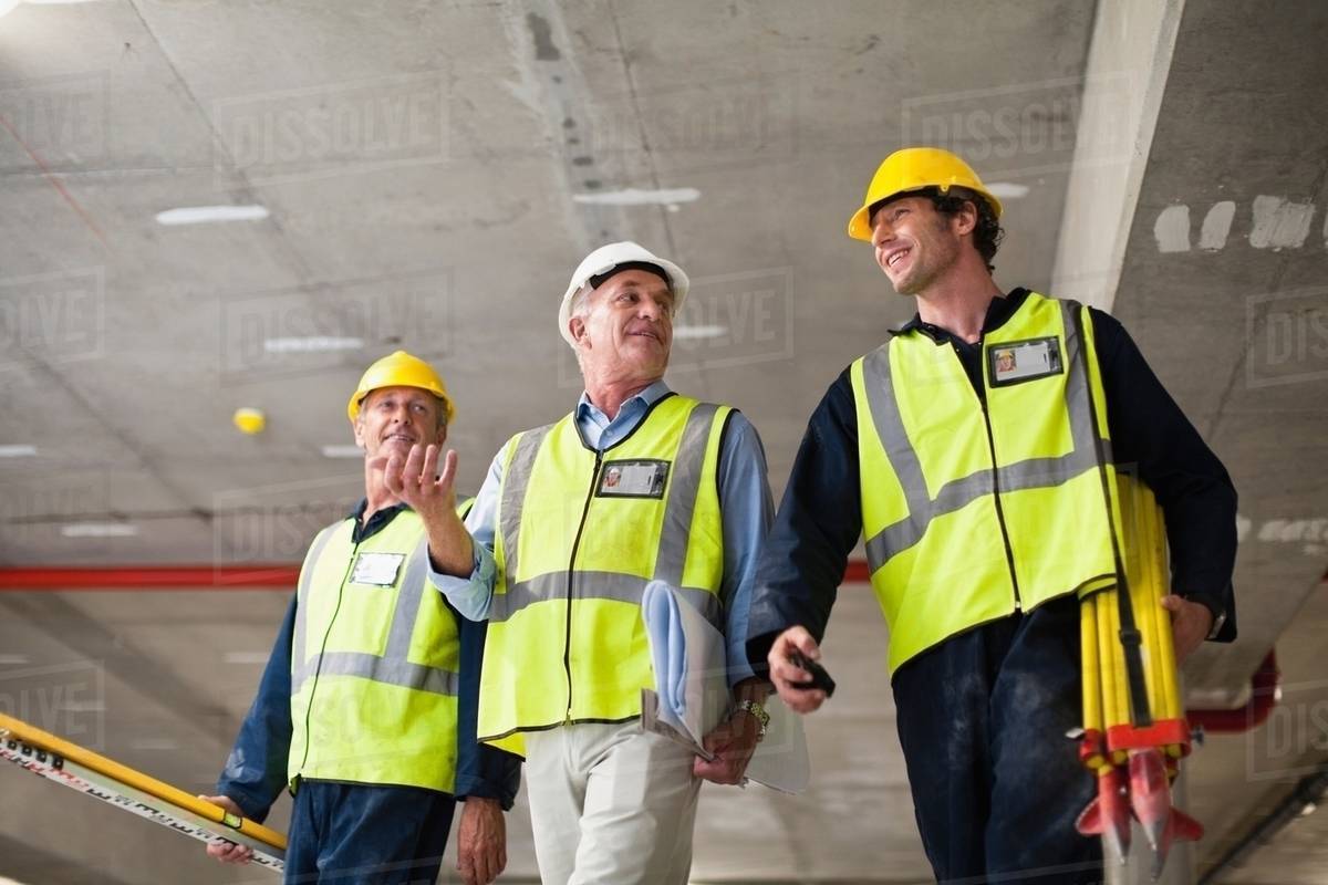 Workers walking at construction site - Royalty-free Stock Photo | Dissolve