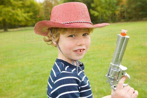 Boy playing with toy gun outdoors - Royalty-free Stock Photo | Dissolve