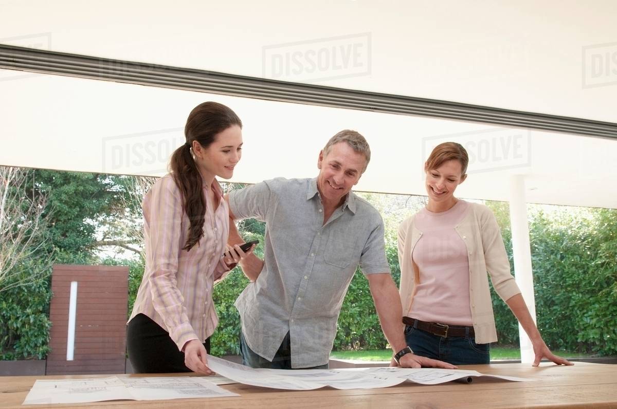 Business people reading blueprints - Royalty-free Stock Photo | Dissolve