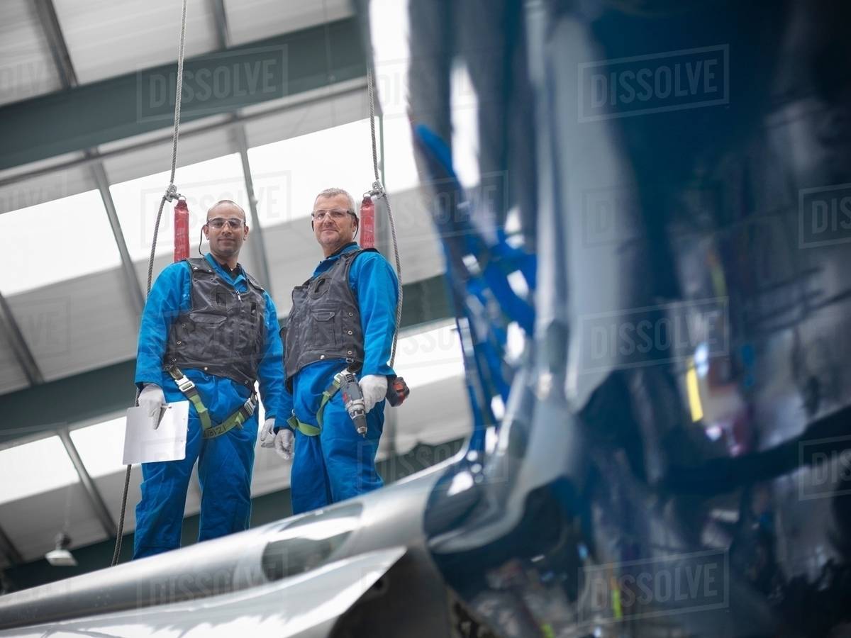 Aircraft engineers working on wing of 737 jet airplane in airport ...