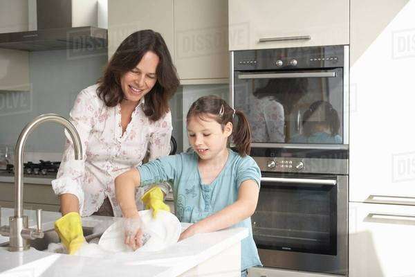 Mother and daughter washing dishes - Stock Photo - Dissolve