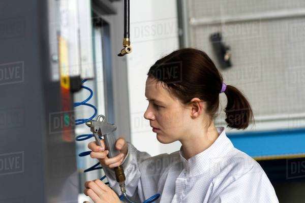 Side view of young woman using compressor gun - Royalty-free Stock ...