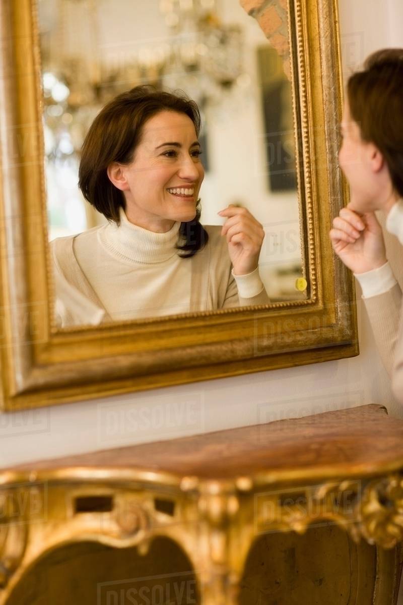Woman looking into mirror - Royalty-free Stock Photo | Dissolve
