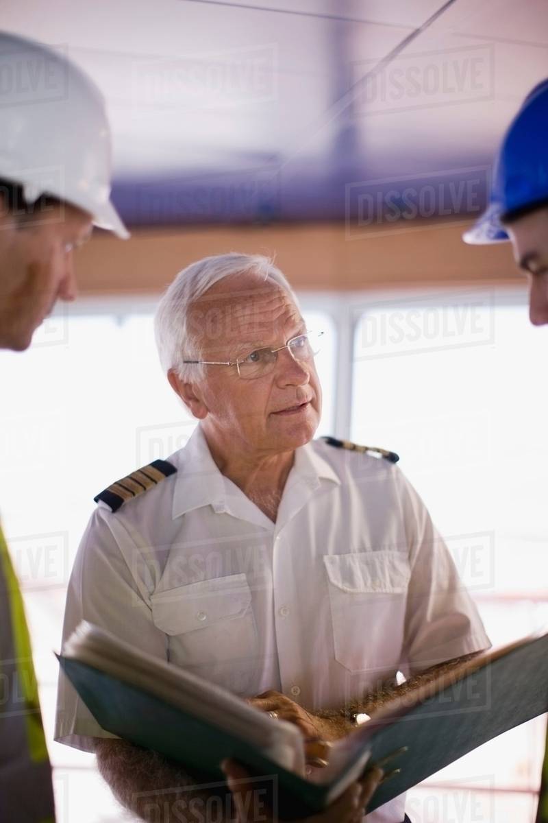 Captain of a ship talking to workers - Stock Photo - Dissolve