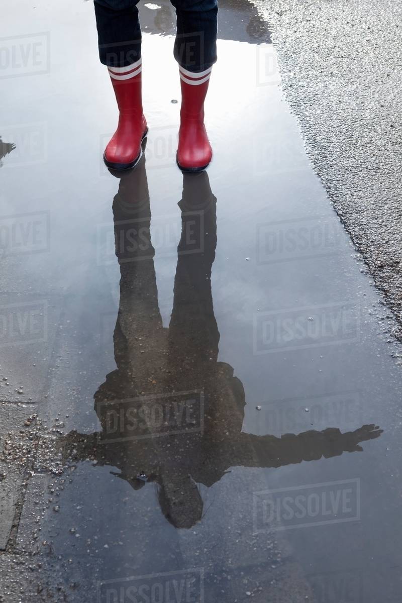 Reflection of a woman in a puddle - Royalty-free Stock Photo | Dissolve