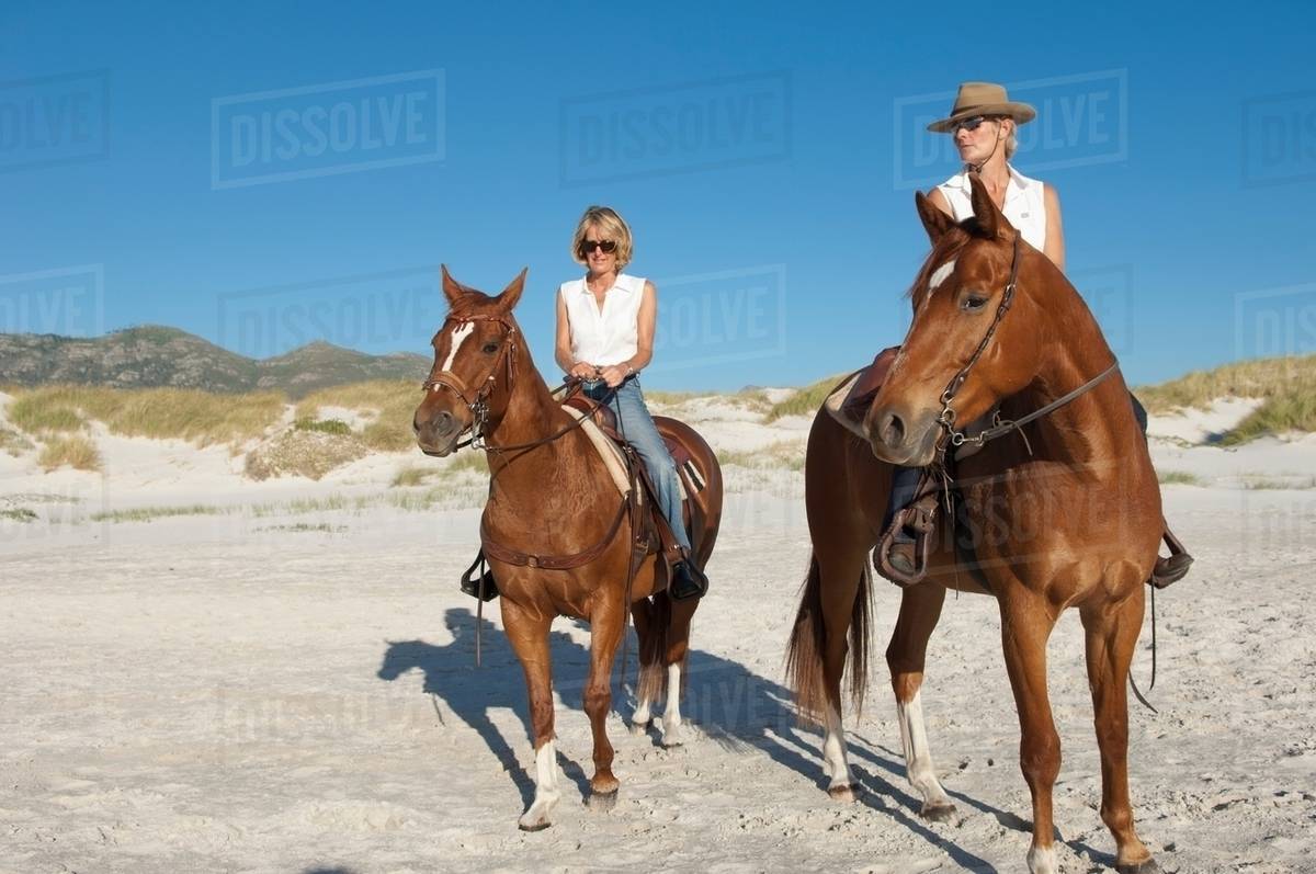 2 people riding horses on the beach - Royalty-free Stock Photo | Dissolve