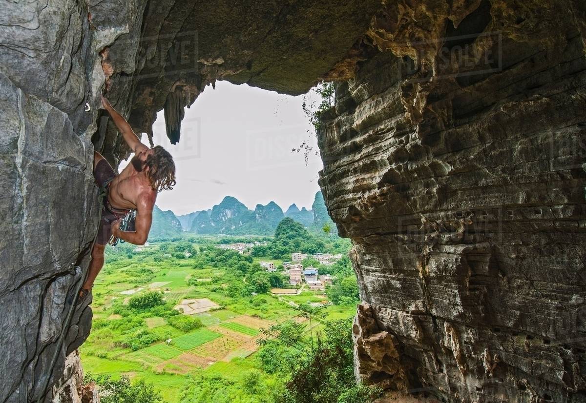Male climber at treasure cave in Yangshuo, Guangxi Zhuang, China ...
