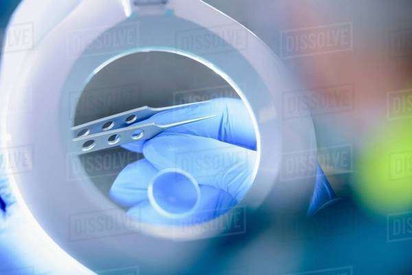 Worker inspecting surgical instruments in clean room of surgical ...