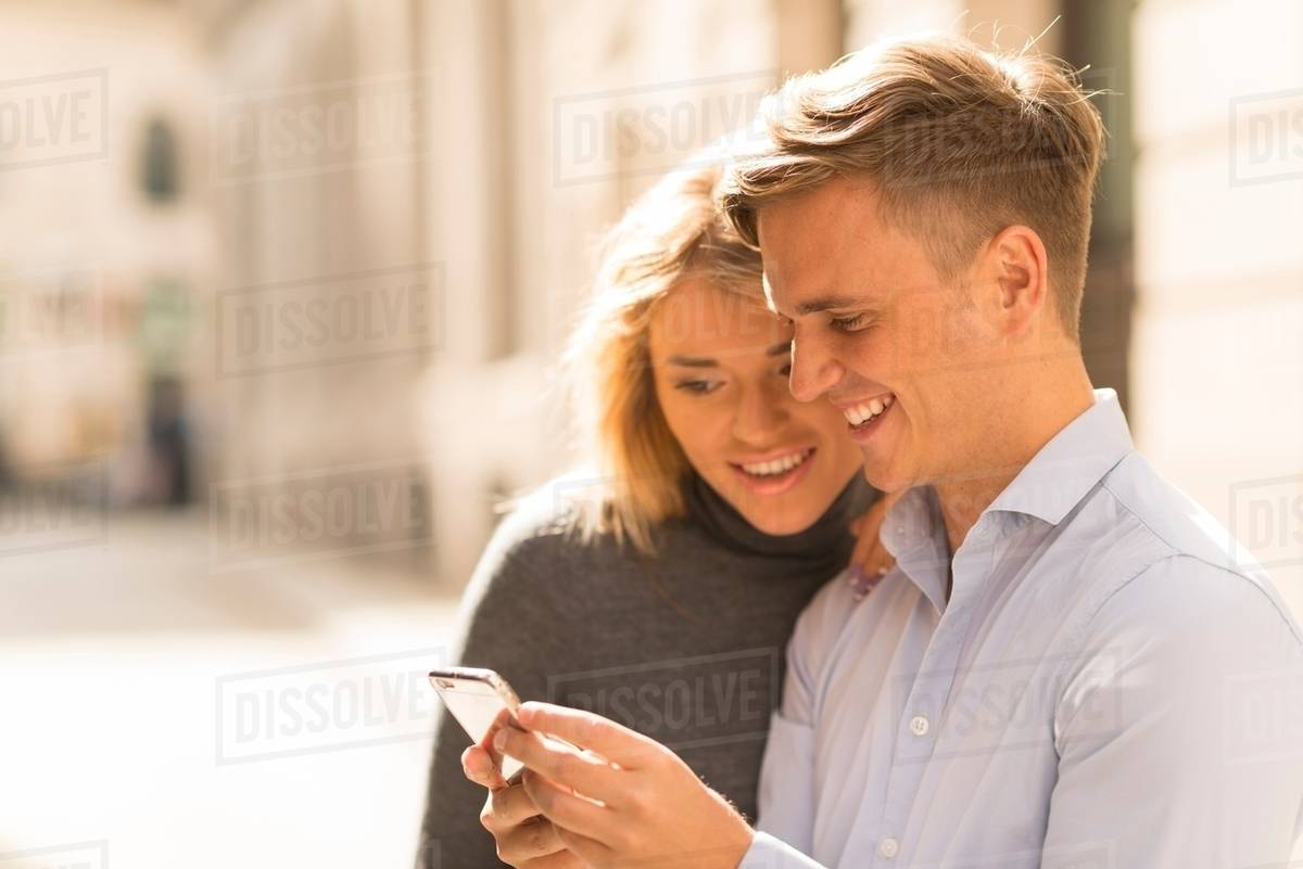 Couple sharing text message in street - Royalty-free Stock Photo | Dissolve