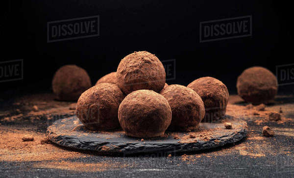 Chocolate truffles, round chocolate candies on black slate background ...