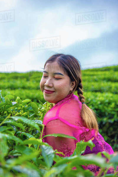 an Asian woman in a traditional pink costume is standing very elegantly ...