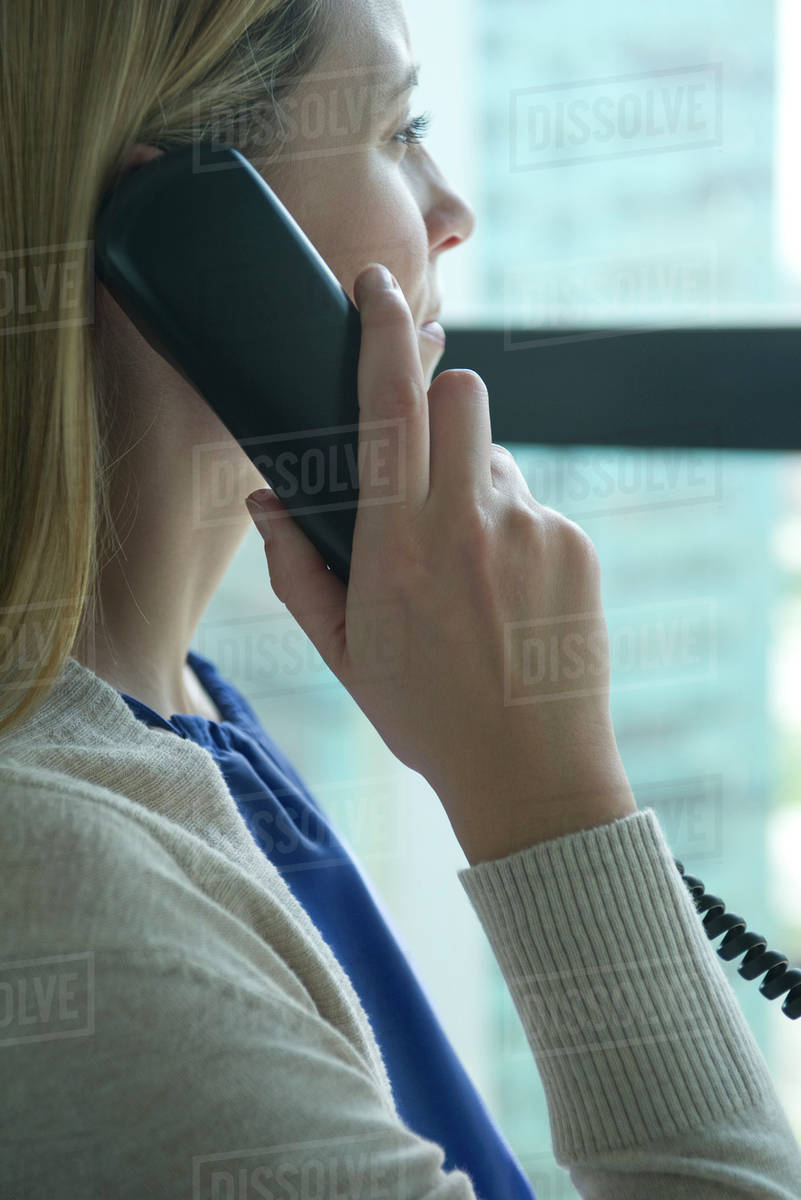 Woman talking on landline phone - Royalty-free Stock Photo | Dissolve