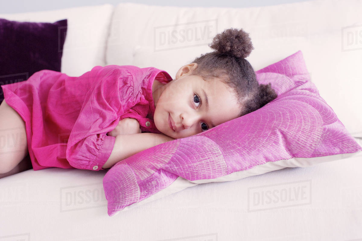 Little girl lying on couch - Royalty-free Stock Photo | Dissolve