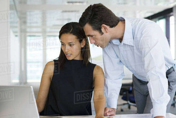 Colleagues working on laptop computer together - Royalty-free Stock ...