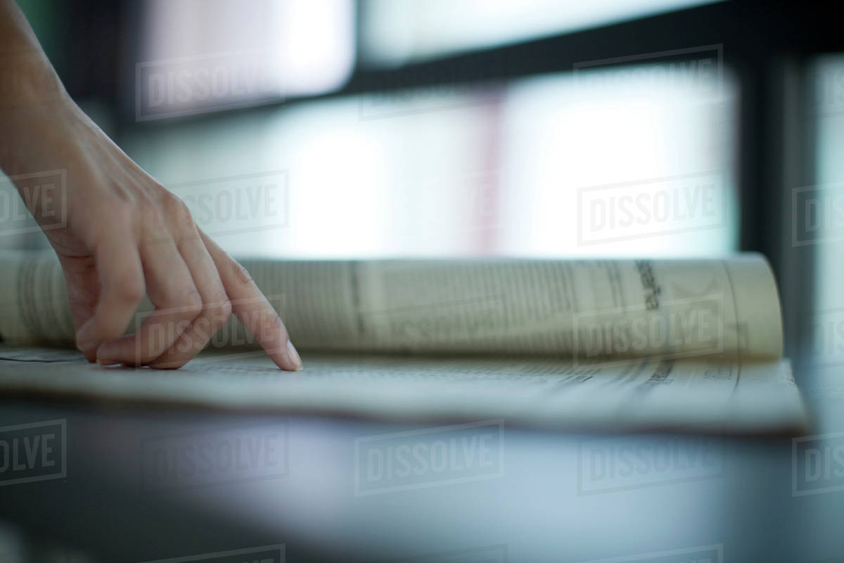 Hand pointing at newspaper, backlit, cropped - Royalty-free Stock Photo ...