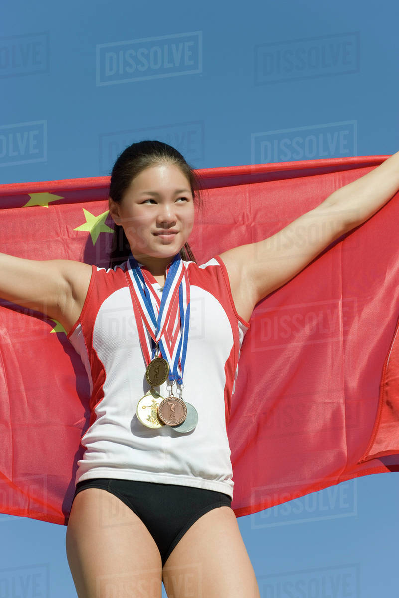 Female athlete on winner's podium, holding Chinese flag - Royalty-free ...