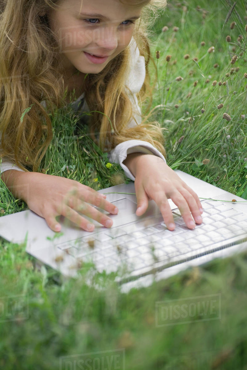 Girl lying in grass, using laptop computer - Royalty-free Stock Photo ...