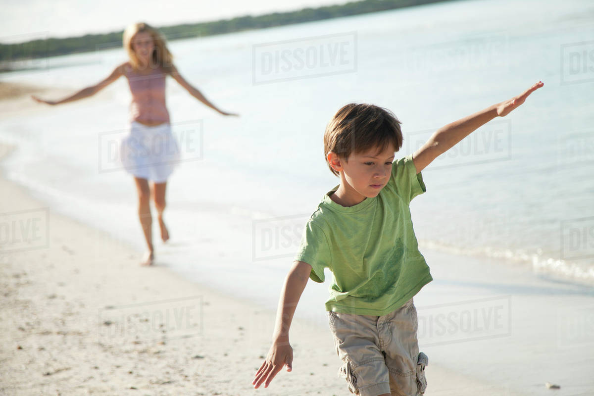 Boy running with arms out at the beach - Royalty-free Stock Photo ...