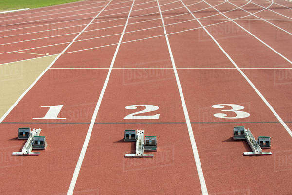 Starting blocks at starting line on running track - Stock Photo - Dissolve