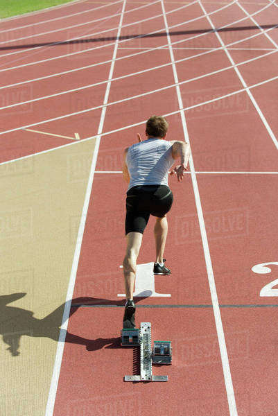 Man running on track, rear view - Stock Photo - Dissolve