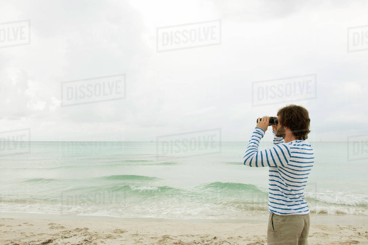 Man looking at view through binoculars - Royalty-free Stock Photo ...
