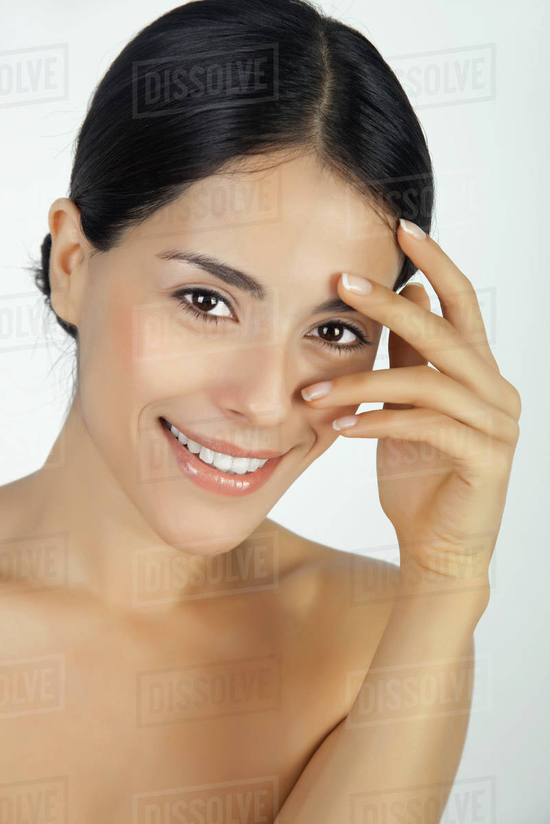 Woman touching face, looking through fingers at camera - Royalty-free ...