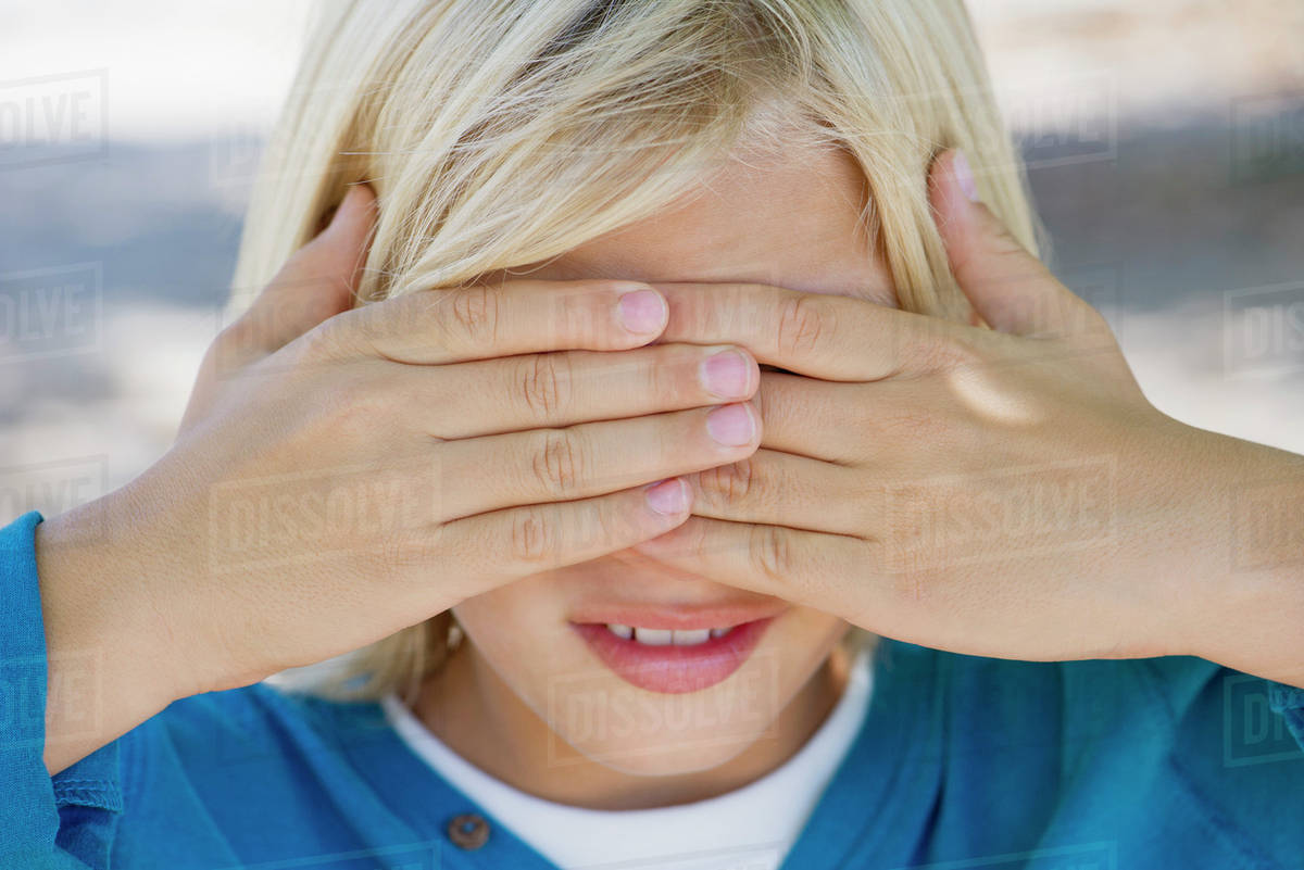 Boy covering eyes with hands - Stock Photo - Dissolve