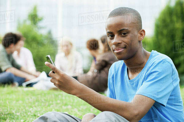 Young man with cell phone, people in background, portrait - Stock Photo ...
