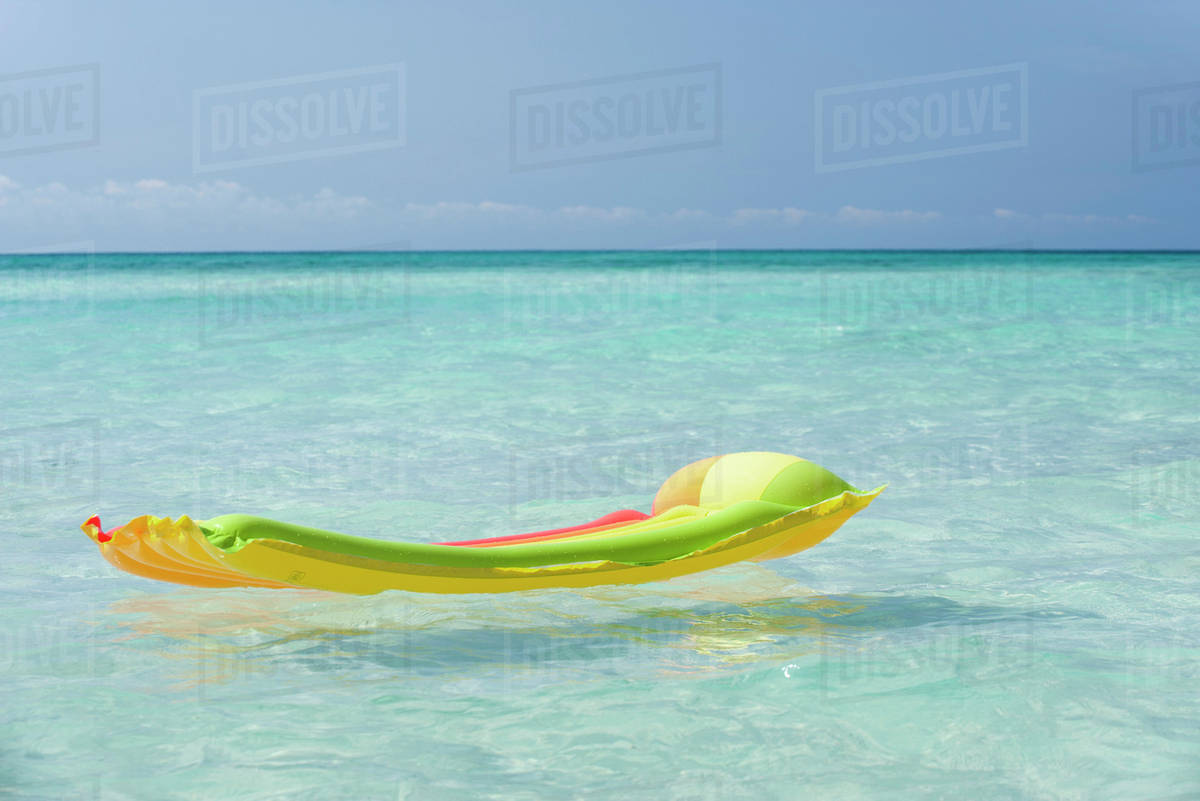 Pool raft floating in ocean - Royalty-free Stock Photo | Dissolve