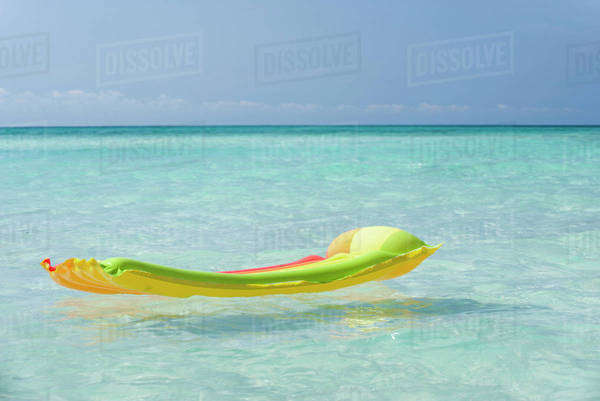 Pool raft floating in ocean - Royalty-free Stock Photo | Dissolve