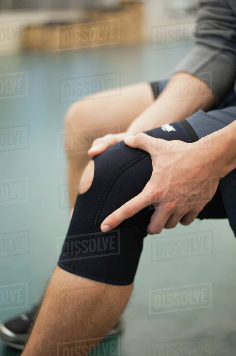 Man wearing knee brace, cropped - Stock Photo - Dissolve