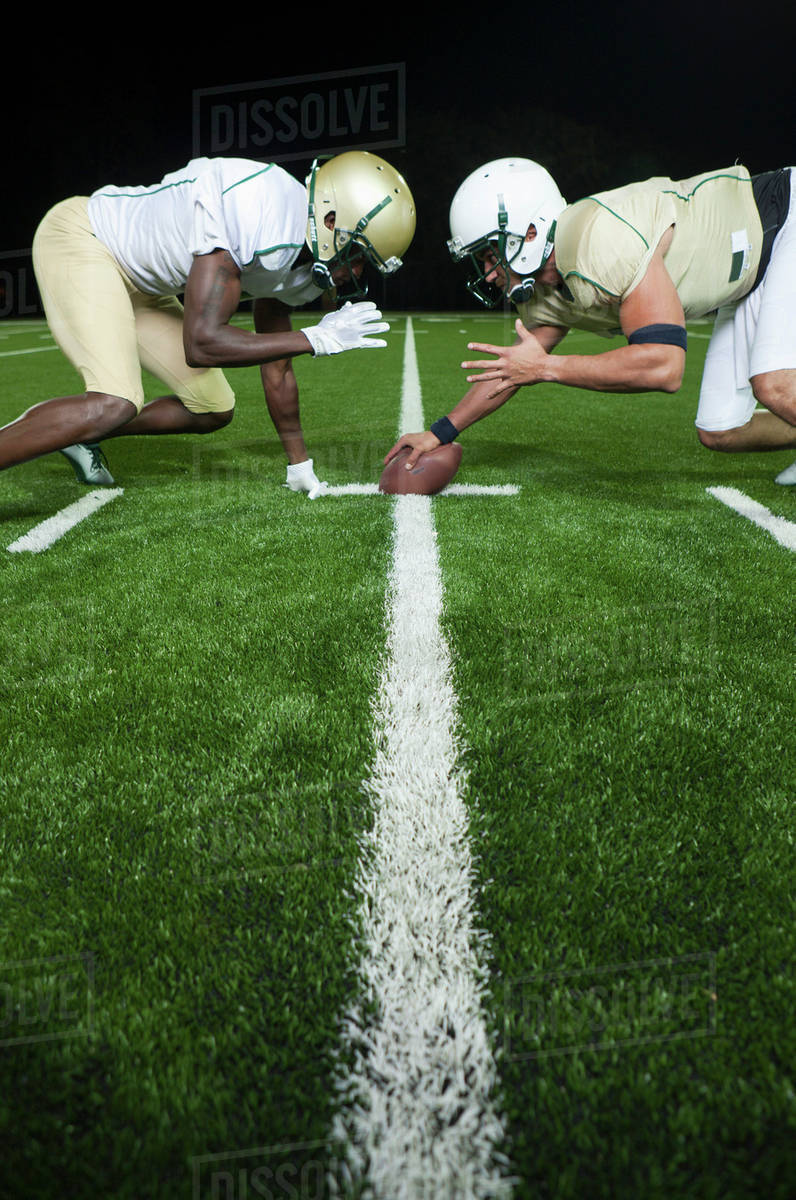 Opposing football players crouched at line of scrimmage - Stock Photo ...