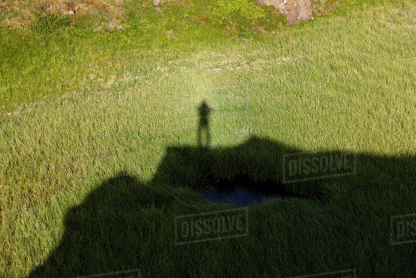 Person's shadow on grass - Royalty-free Stock Photo | Dissolve