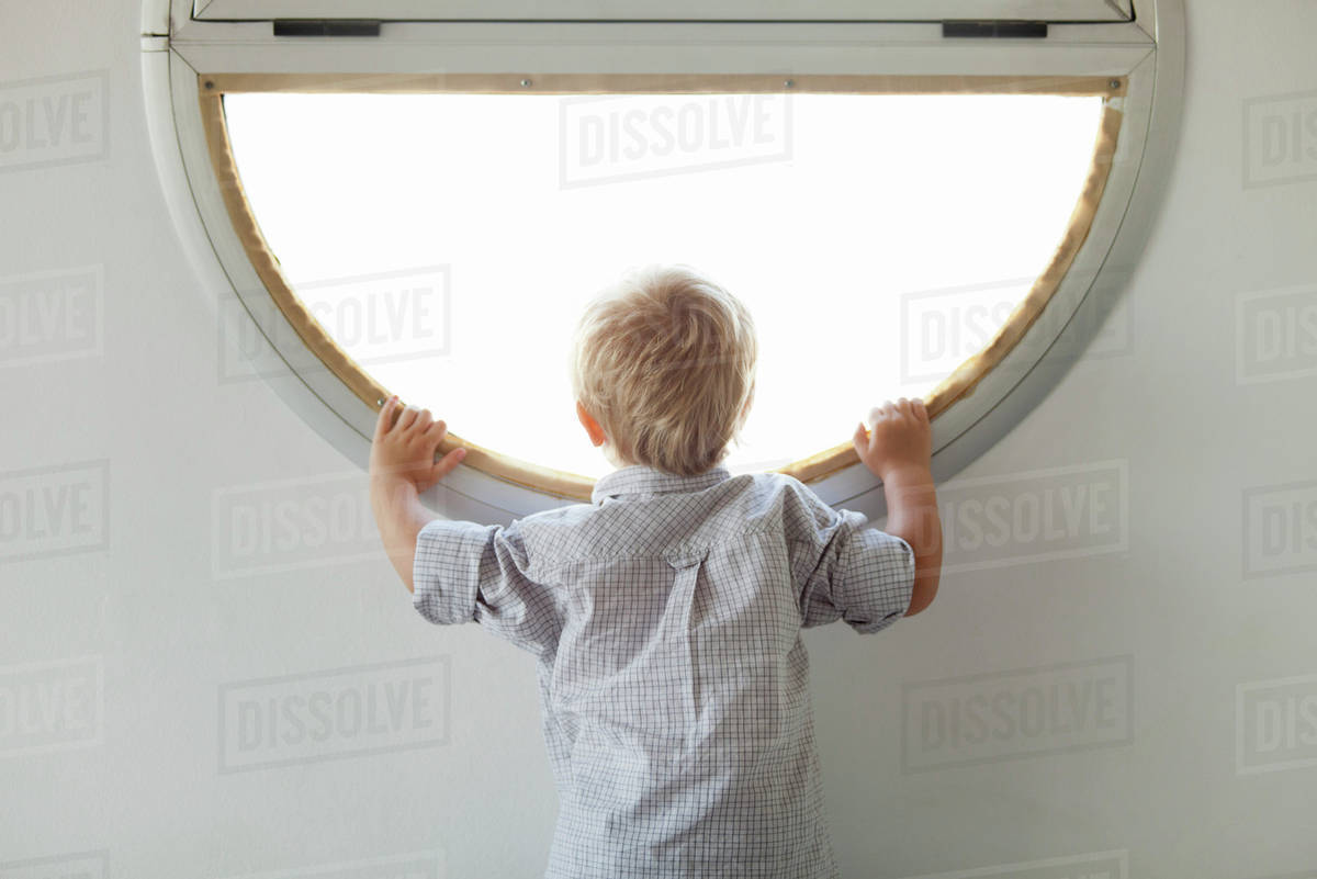 Little boy looking through window, rear view - Royalty-free Stock Photo ...