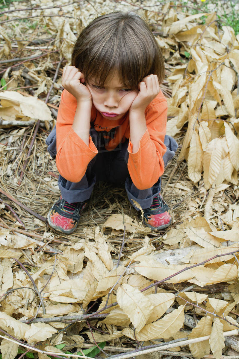 Boy sulking outdoors - Royalty-free Stock Photo | Dissolve