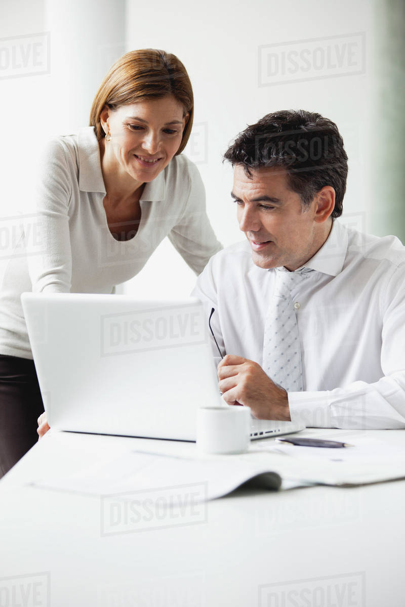 Business colleagues looking at laptop computer together - Stock Photo ...