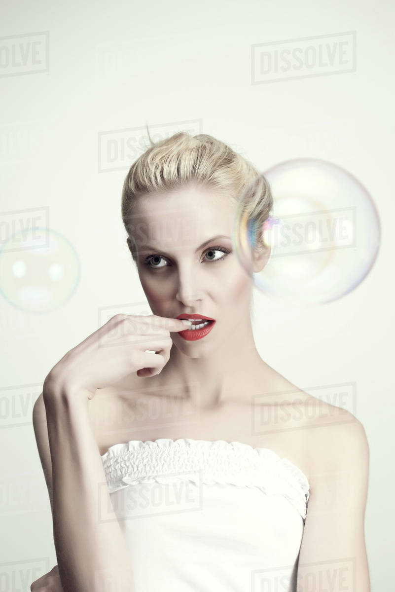 Young woman biting finger, portrait - Royalty-free Stock Photo | Dissolve