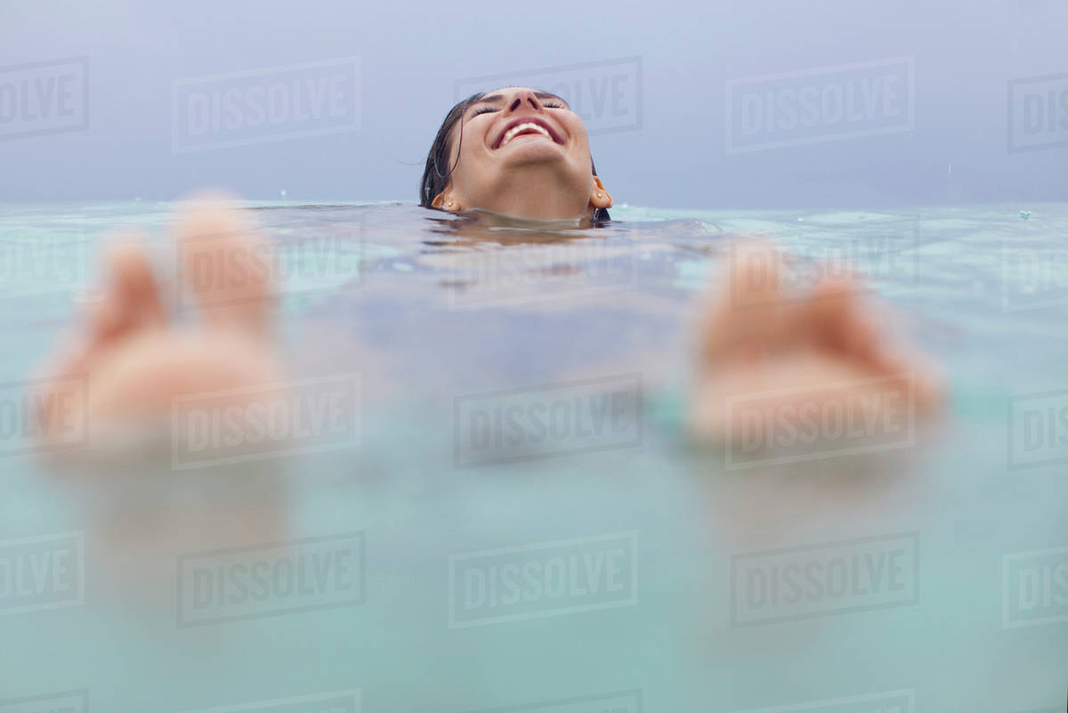 Woman floating in water - Stock Photo - Dissolve