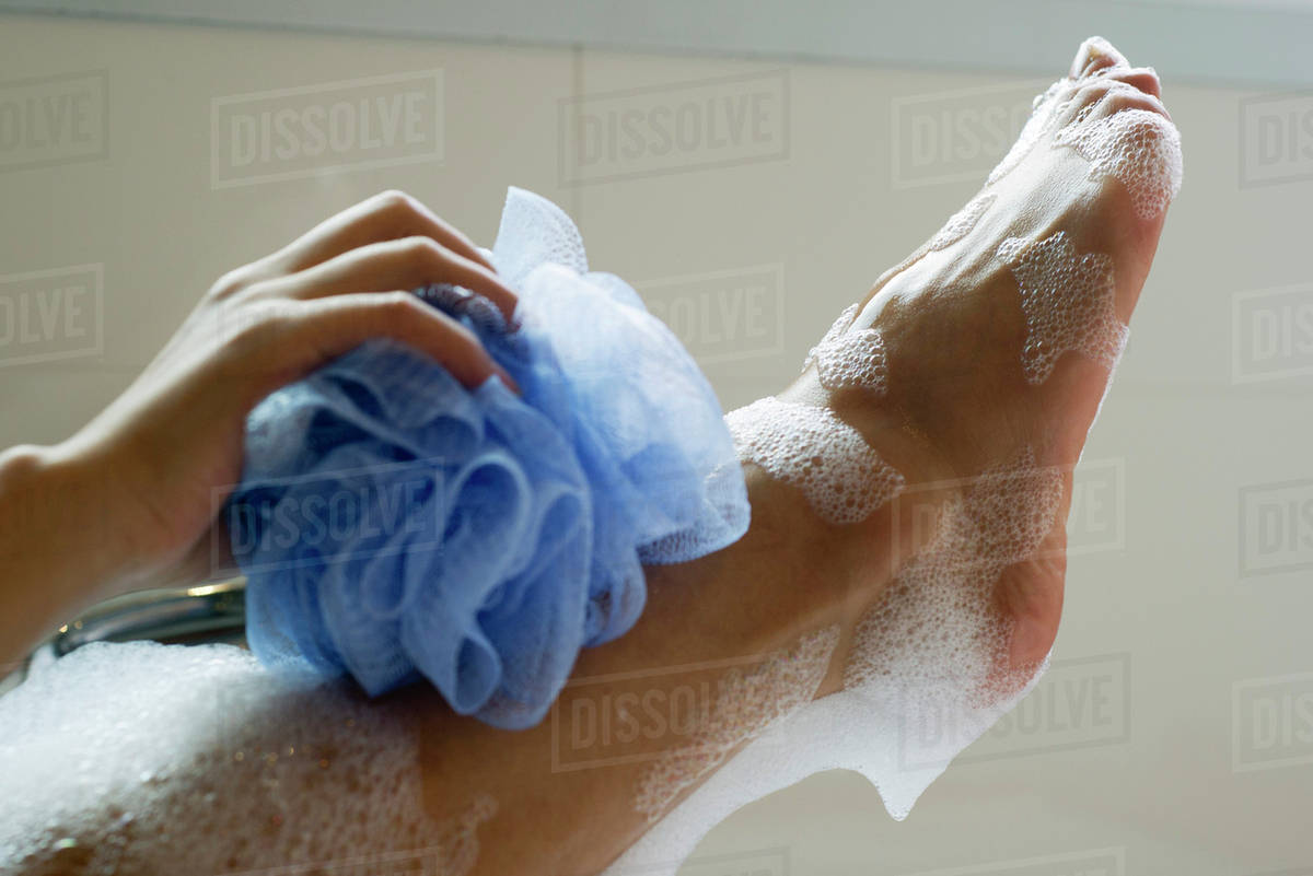Woman washing foot with bath sponge, cropped - Royalty-free Stock Photo ...