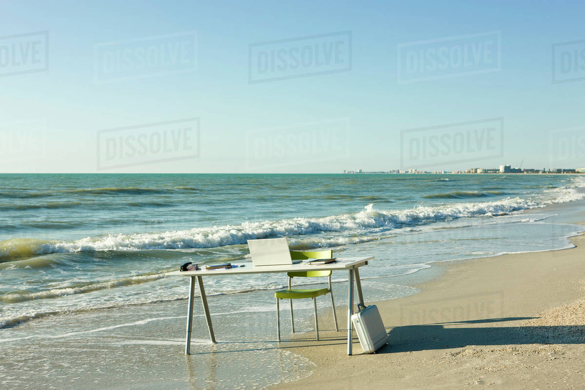 Desk and laptop computer on beach - Royalty-free Stock Photo | Dissolve