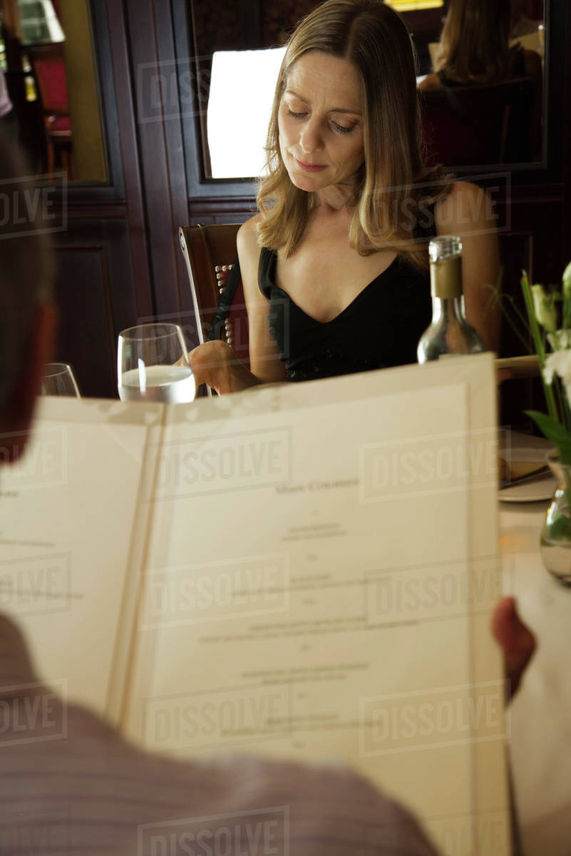 Couple reading menus in restaurant - Royalty-free Stock Photo | Dissolve