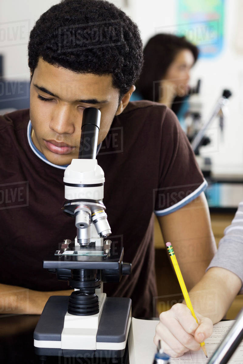 High school student looking through microscope - Royalty-free Stock ...