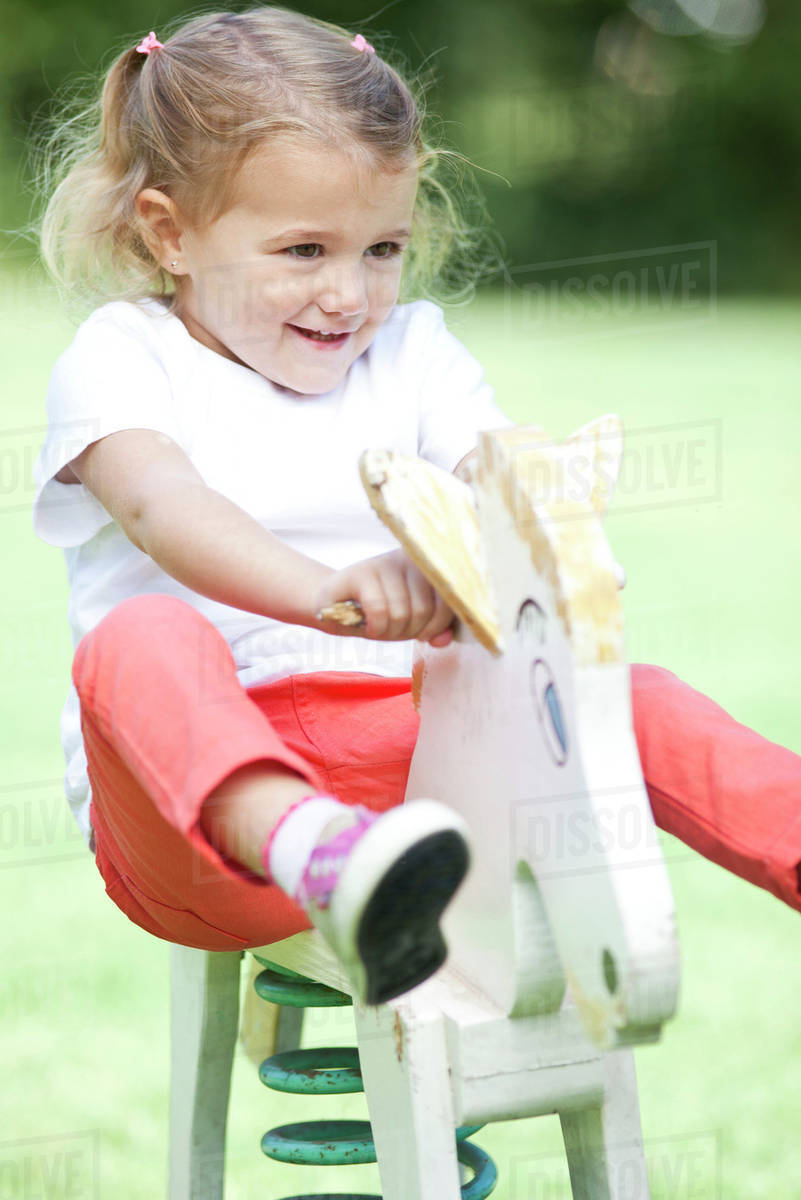 Little girl riding rocking horse, portrait - Royalty-free Stock Photo ...