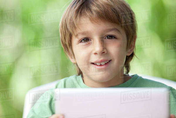 Boy holding digital tablet - Royalty-free Stock Photo | Dissolve