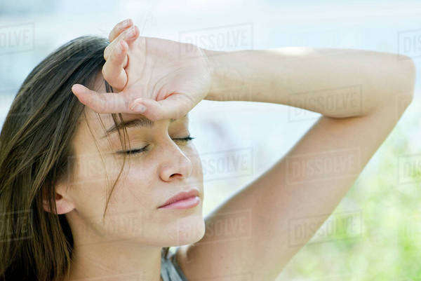 Woman with hand on forehead - Stock Photo - Dissolve