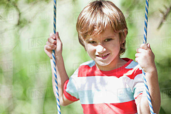 Boy on swing, portrait - Royalty-free Stock Photo | Dissolve